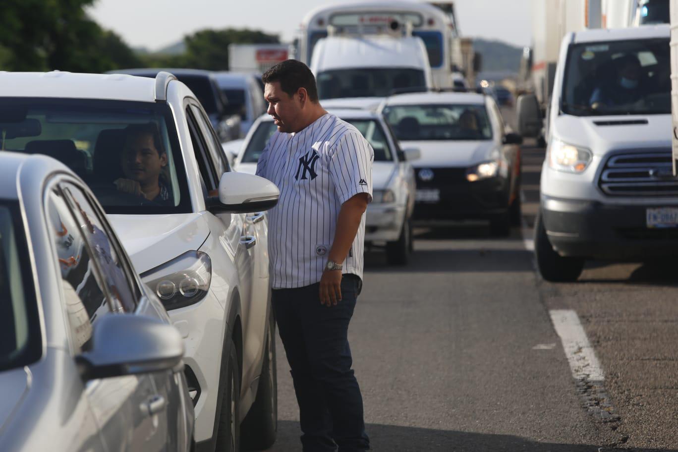 La gente, ‘atrapada’ por el cierre de la autopista, se brinca el muro ...